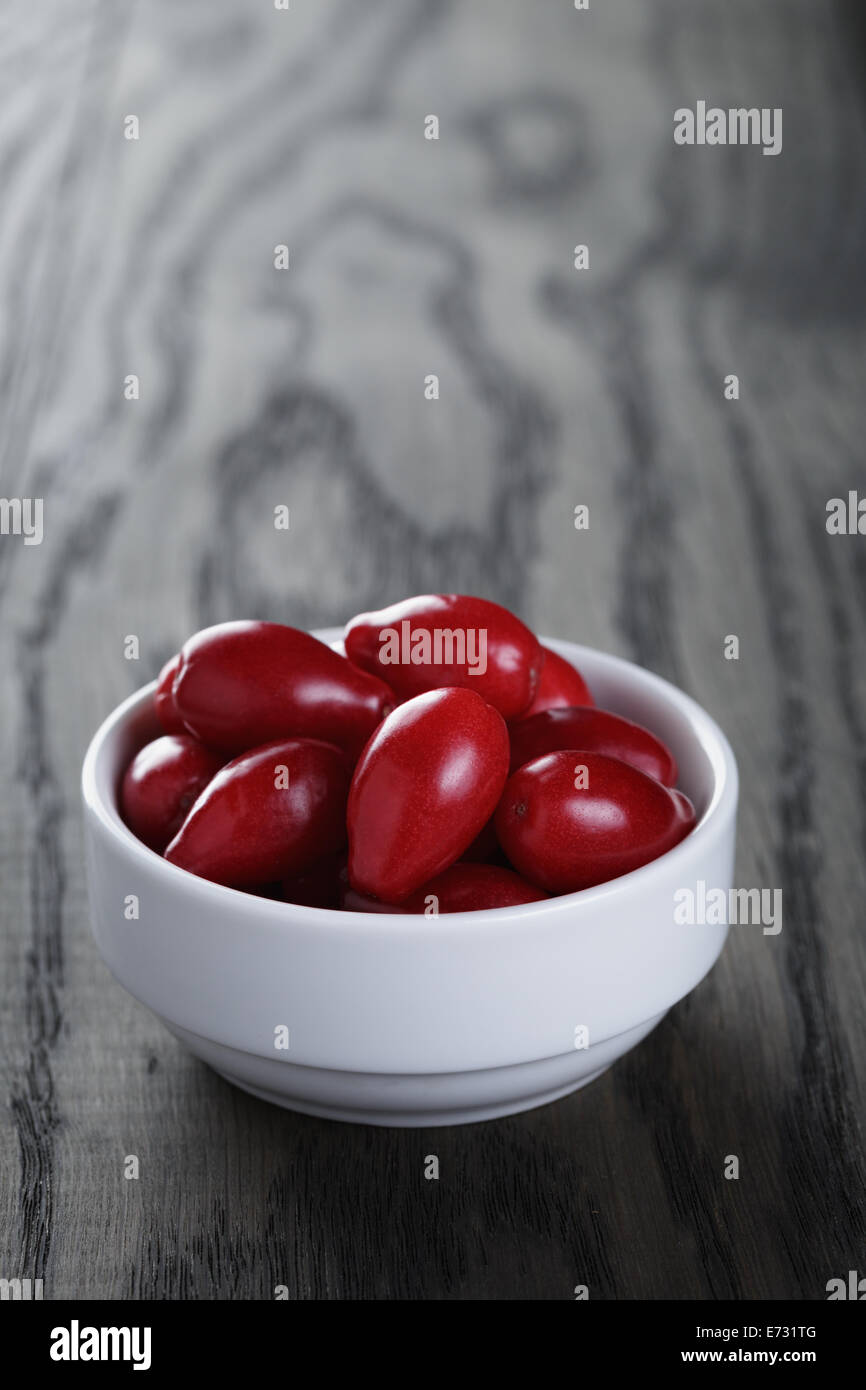 ripe cornel berries in bowl, on old wood table Stock Photo - Alamy