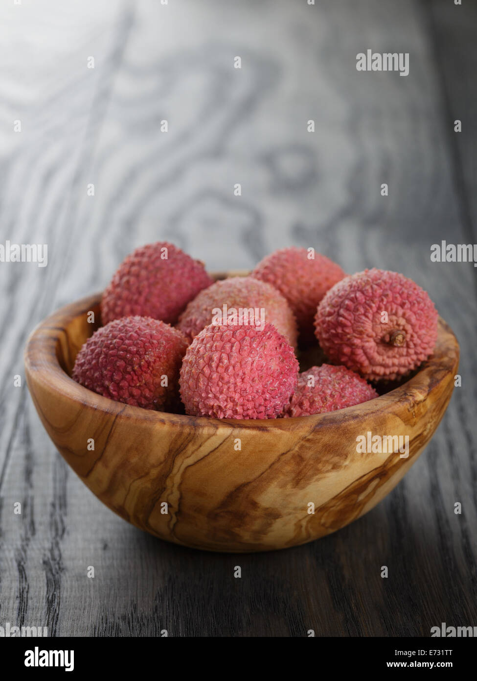 ripe lychees in wood bowl, on old oak table Stock Photo - Alamy
