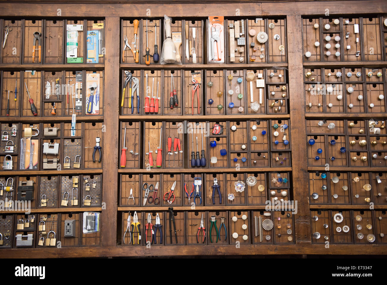 Wall display of tools and cabinet fittings on a wood background divided ...