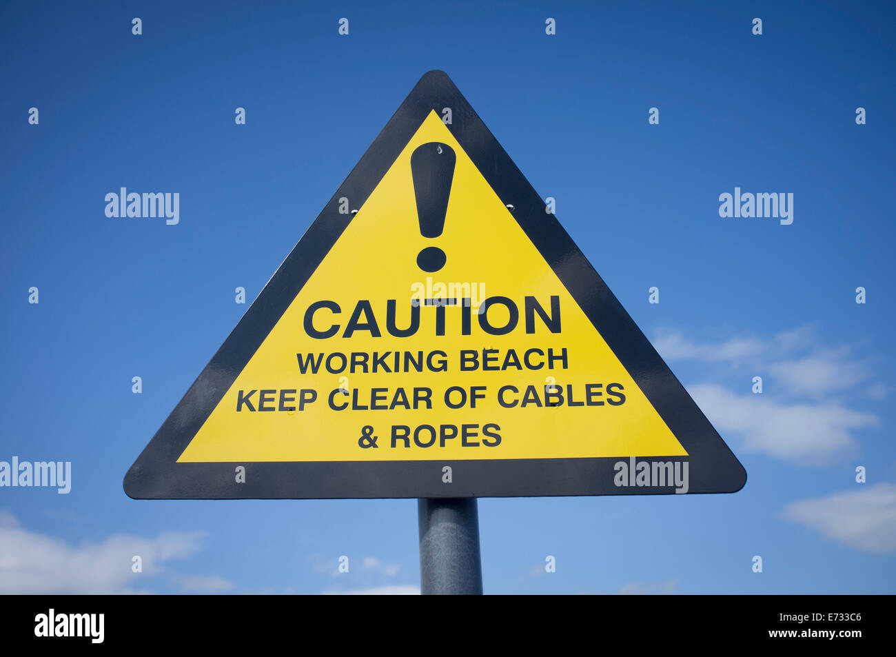 yellow caution sign warning of cables and ropes due to use by the ...