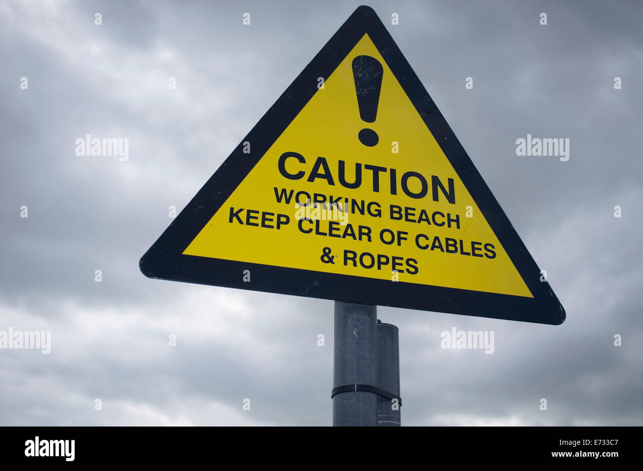 yellow caution sign warning of cables and ropes due to use by the ...