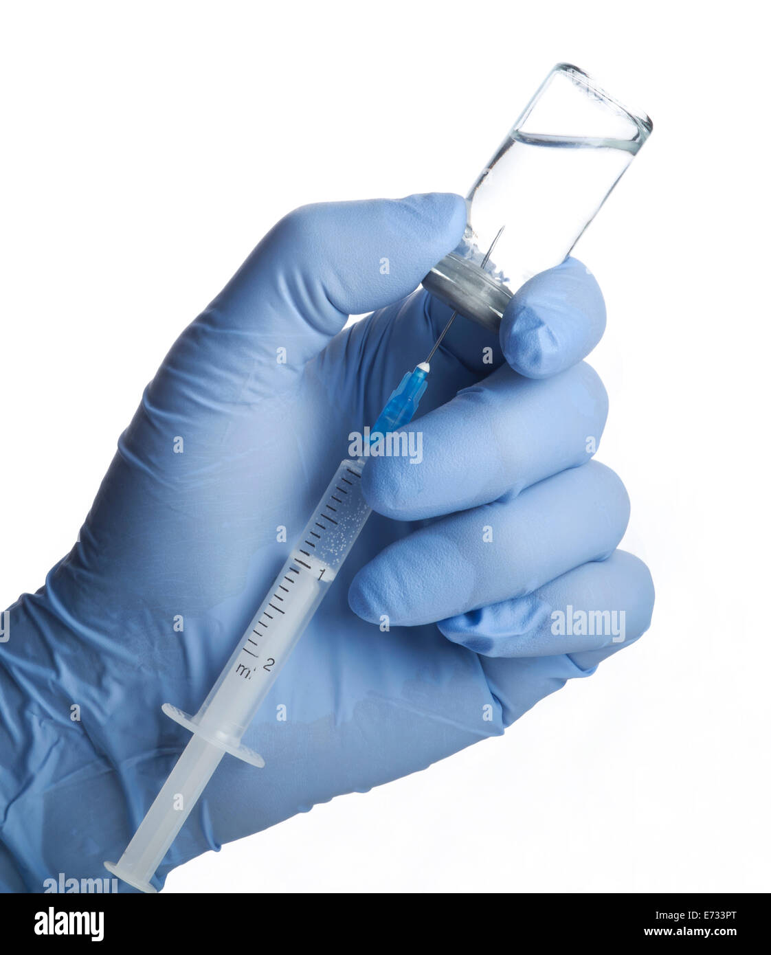 Hand holding glass medicine vial and syringe on a white background ...