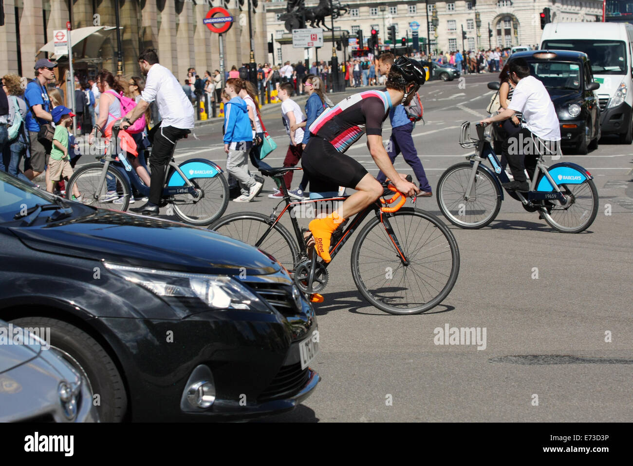A cyclist and cars crossing a junction while other cyclists and ...