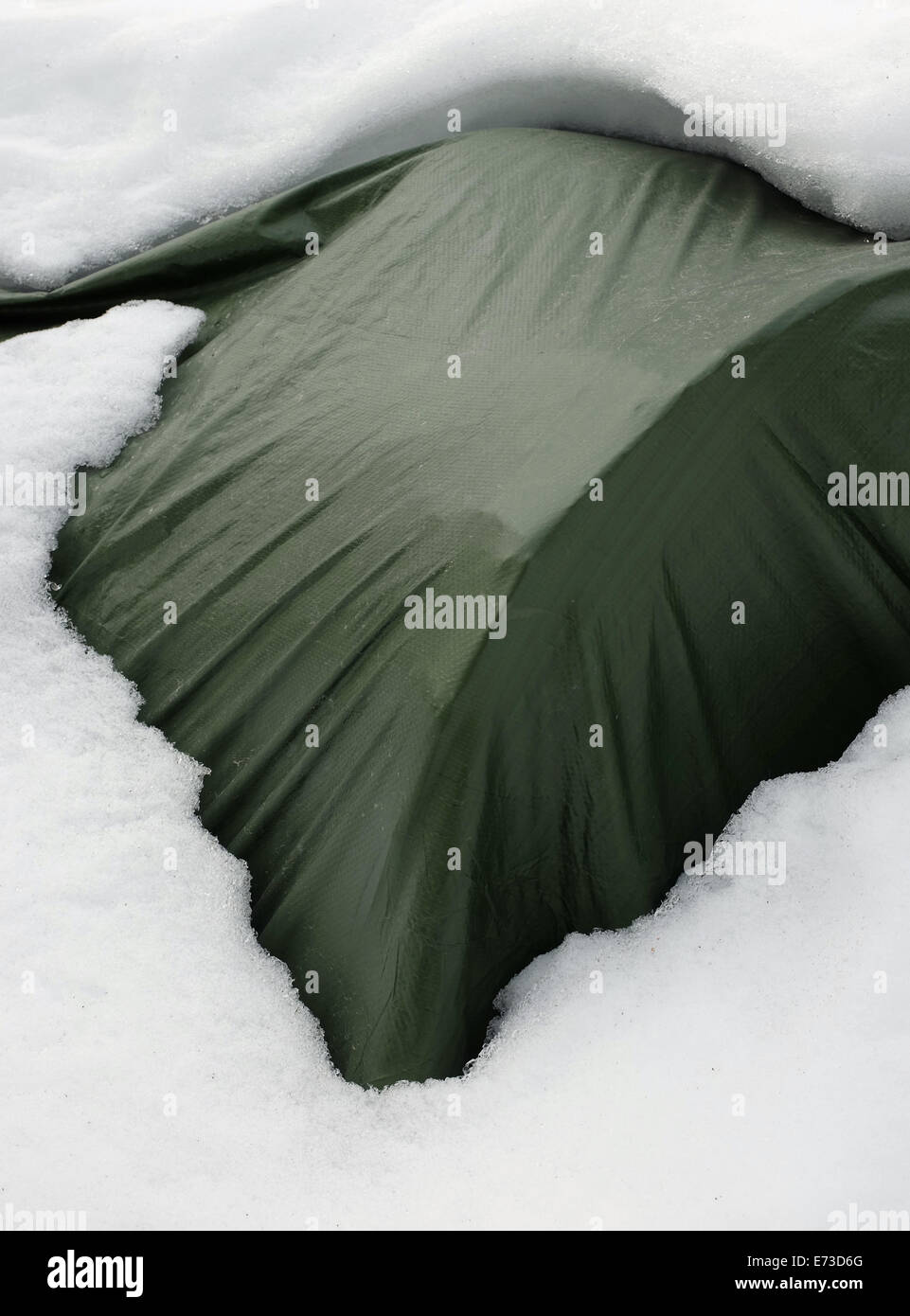 Green Vinyl Tarp in Snow Stock Photo - Alamy