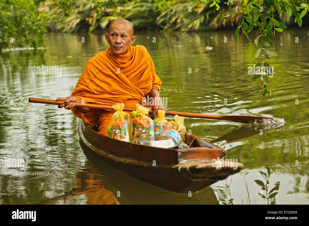 Monk rowing his boat at the Ampawa Floating Market Stock Photo - Alamy