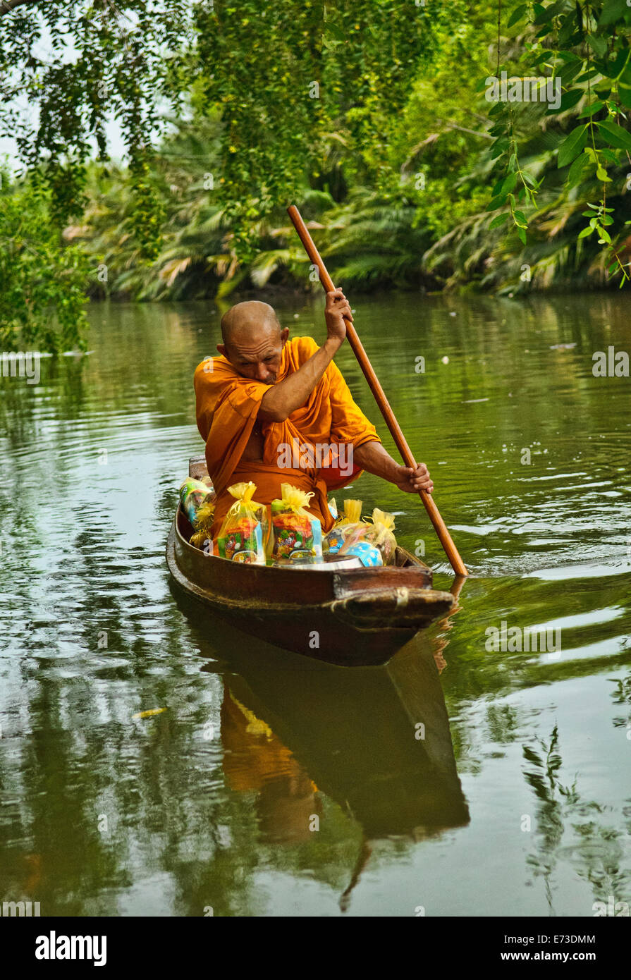 Monk rowing his boat at the Ampawa Floating Market Stock Photo - Alamy