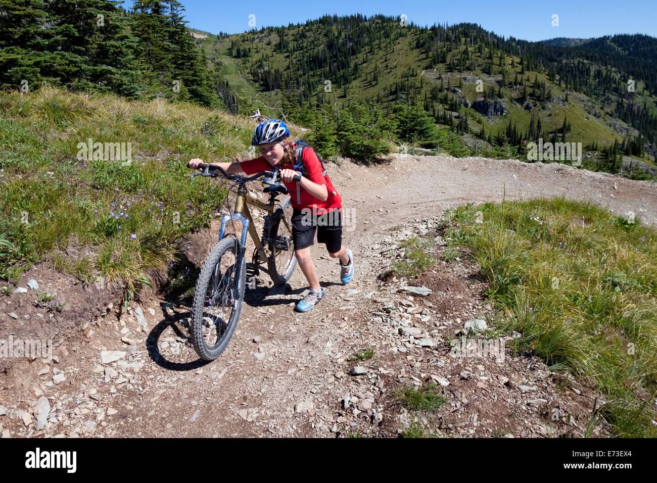 A teenage girl pushes her mountain bike in Whitefish, Montana Stock ...