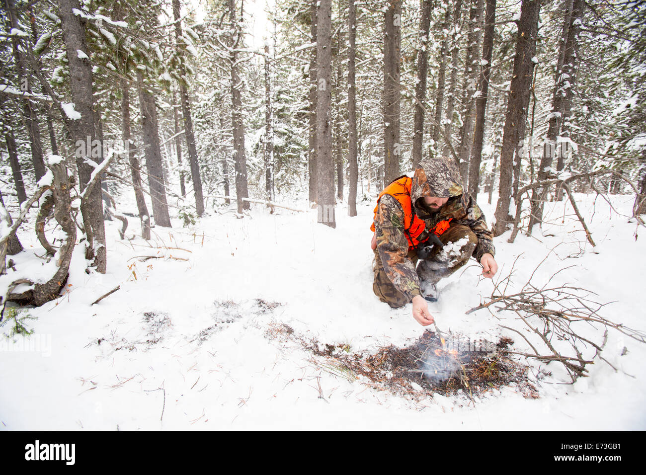 A male hunter starts a fire in the snow Stock Photo - Alamy