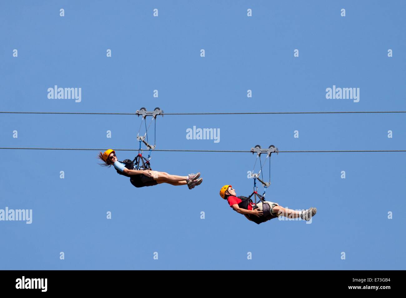 Two women ride a zip line in Whitefish, Montana Stock Photo - Alamy