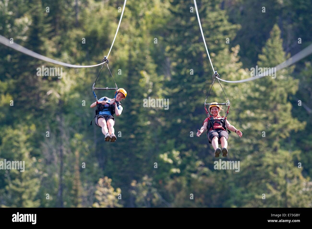 Two women on a zip line in Whitefish, Montana Stock Photo - Alamy