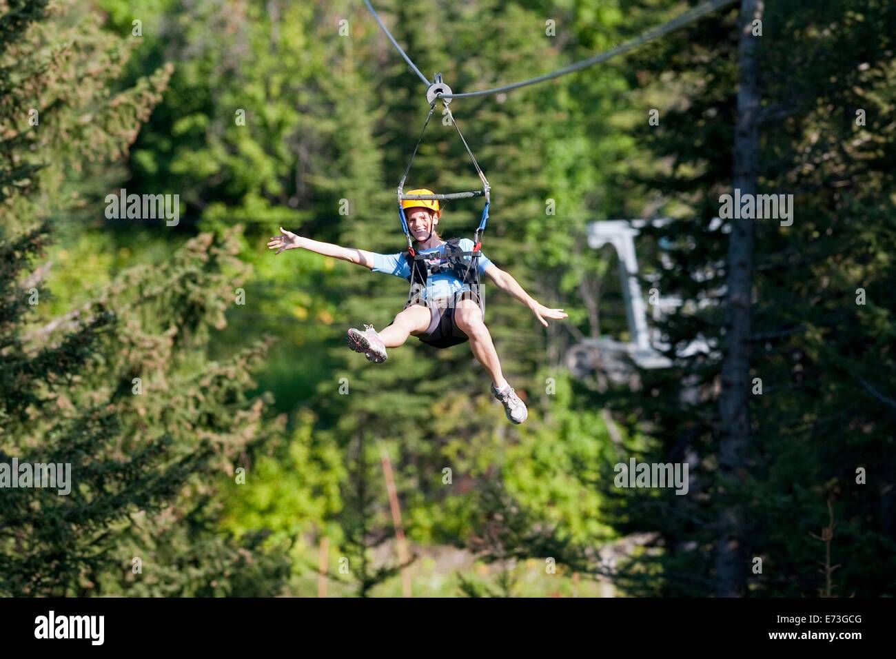 A woman on a zip line tour in Whitefish, Montana Stock Photo - Alamy