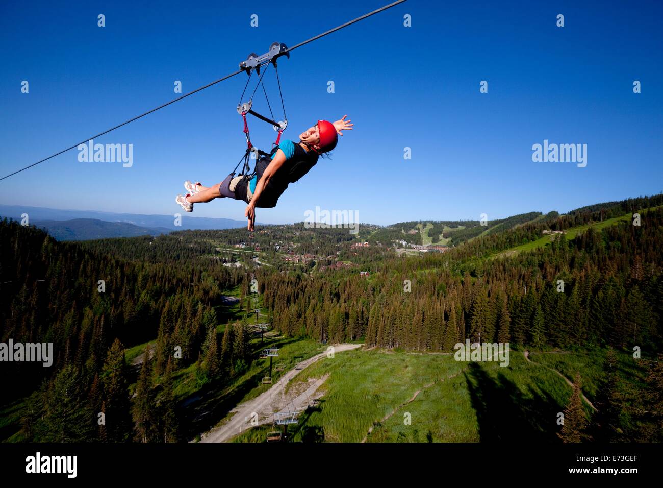 Woman on a zip line smiling Stock Photo - Alamy
