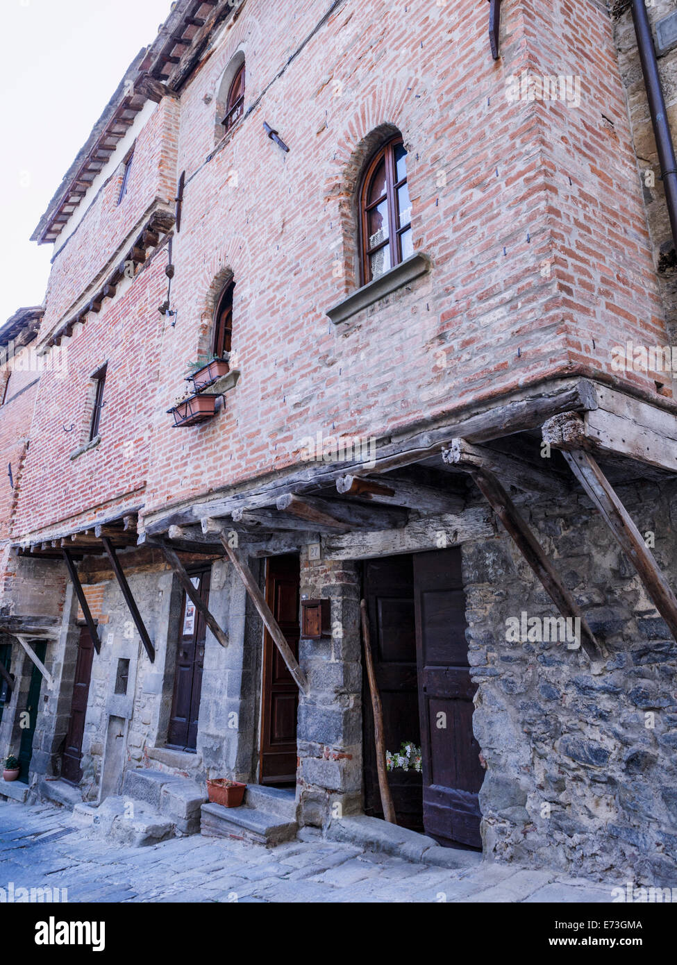 Original brick and overhanging medieval houses in Cortona, Tuscany ...
