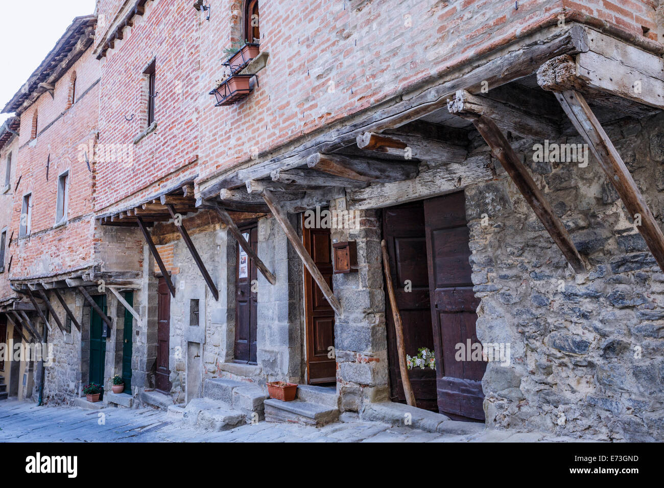 Original brick and overhanging medieval houses in Cortona, Tuscany ...