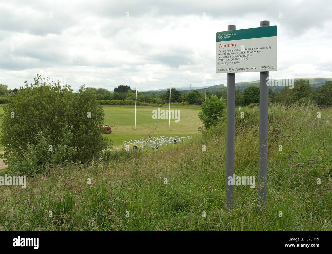 Grey sky view Flood Storage Reservoir Information Sign on top of levee ...