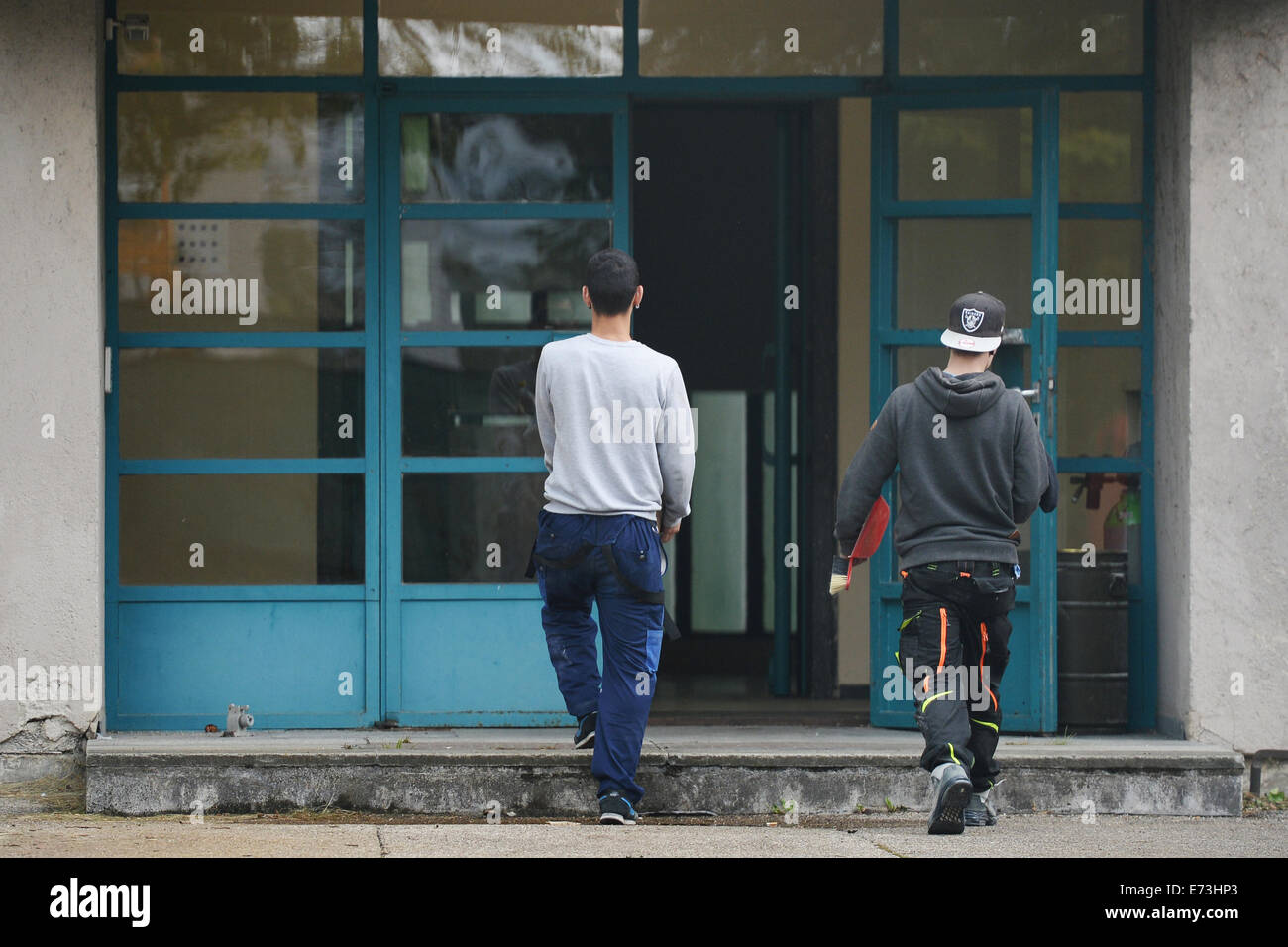 Munich, Germany. 30th Aug, 2014. Two young men entre the building of a ...