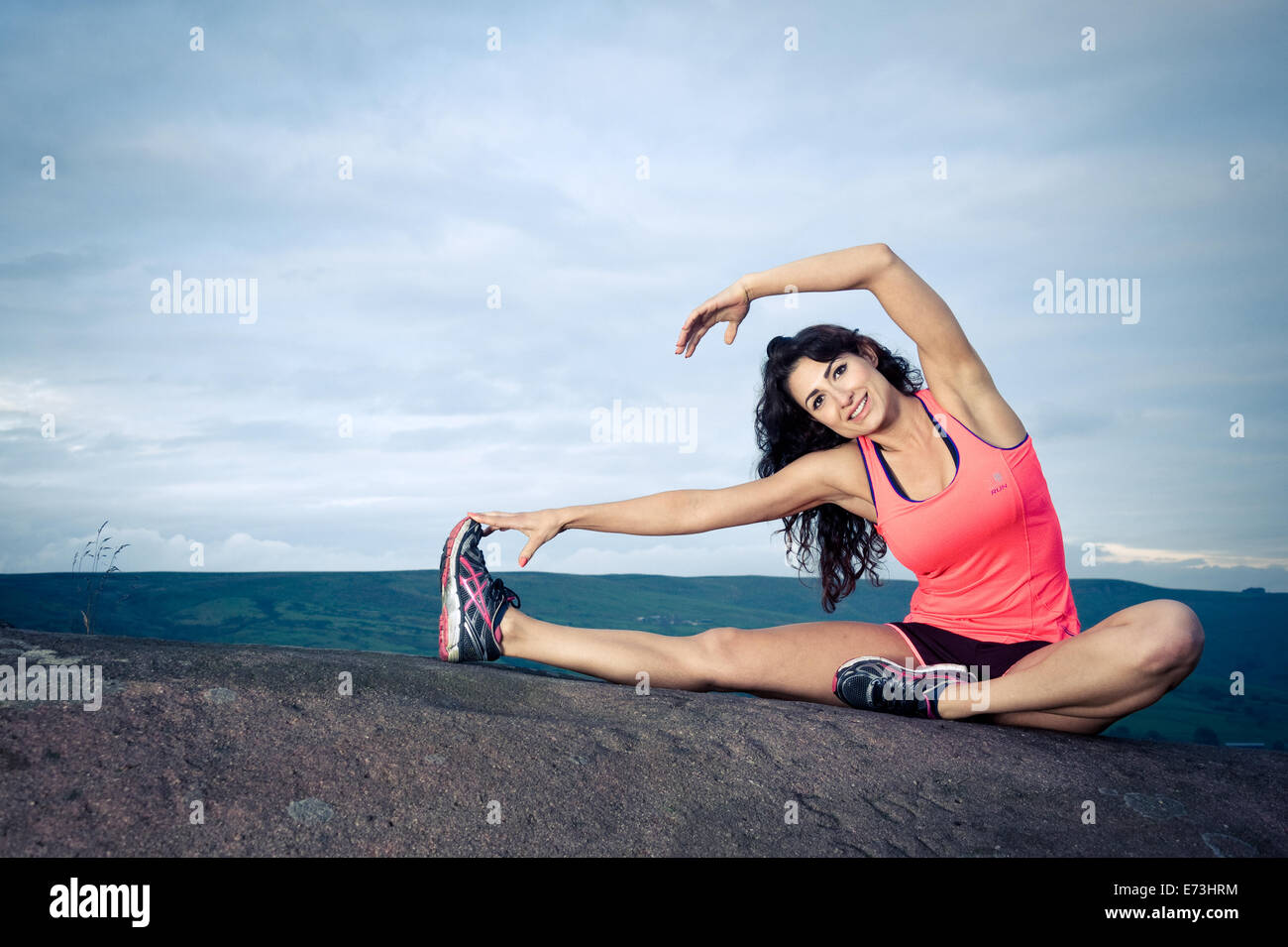 Woman performing warm up stretch Stock Photo - Alamy