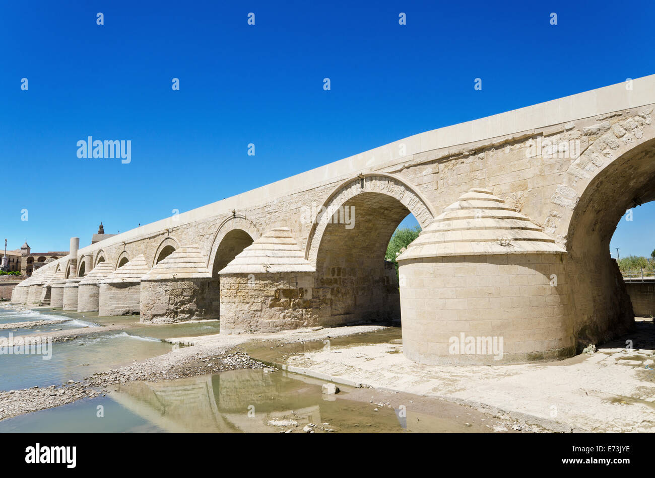 Roman bridge and Guadalquivir river over blue bright sky in Cordoba ...