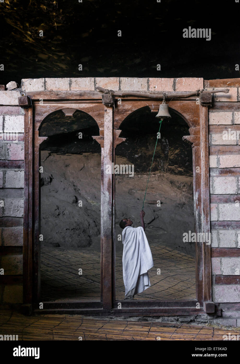 Priest Ringing The Bell Inside Yemrehana Krestos Rock Church, Lalibela ...