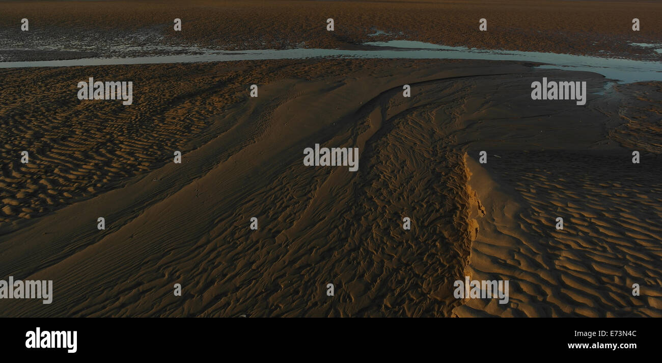 Evening sun view dry braided stream channel incising sand ripples beach ...