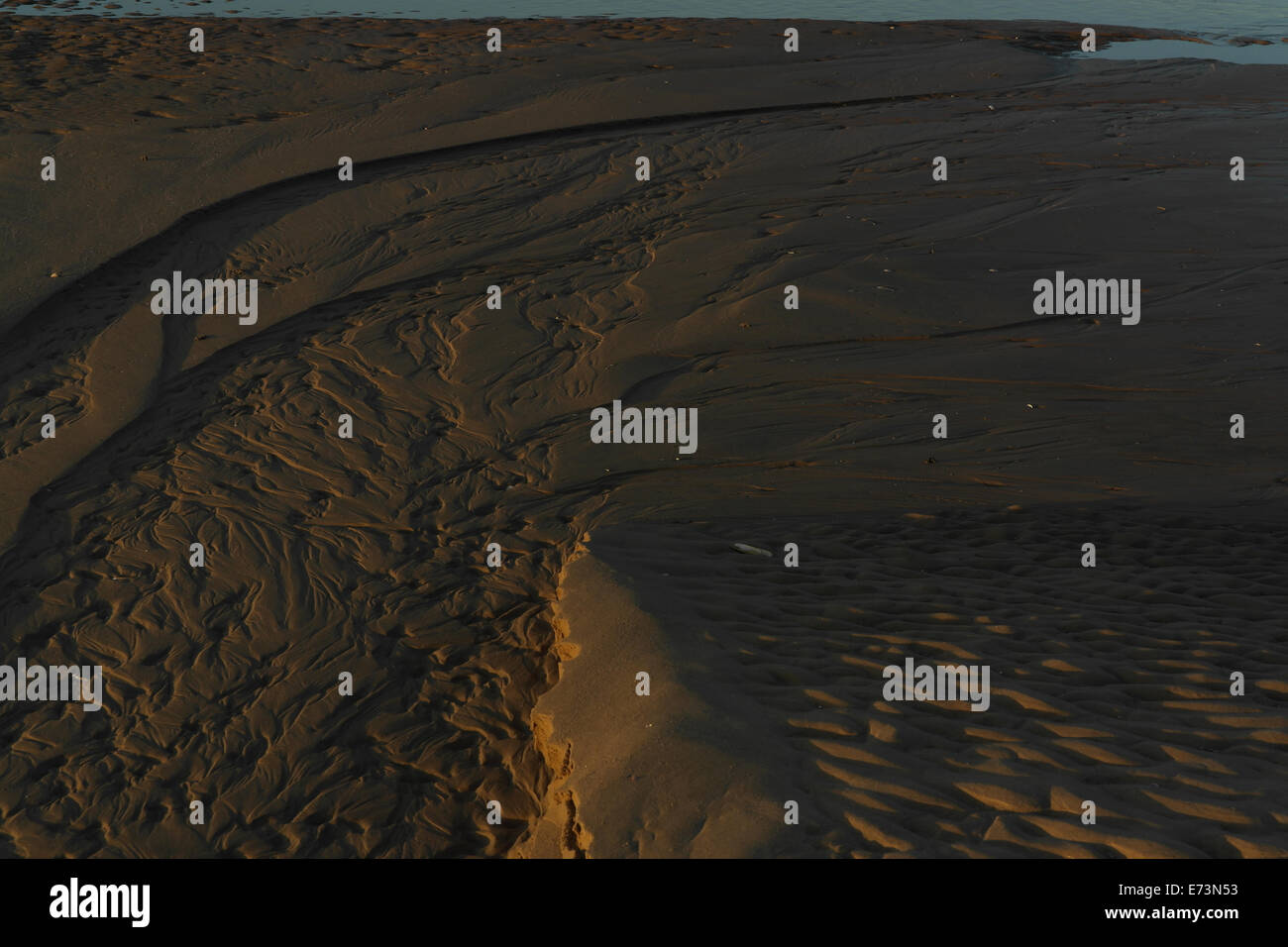 Evening sun view dry braided stream channel incising beach with sand ...