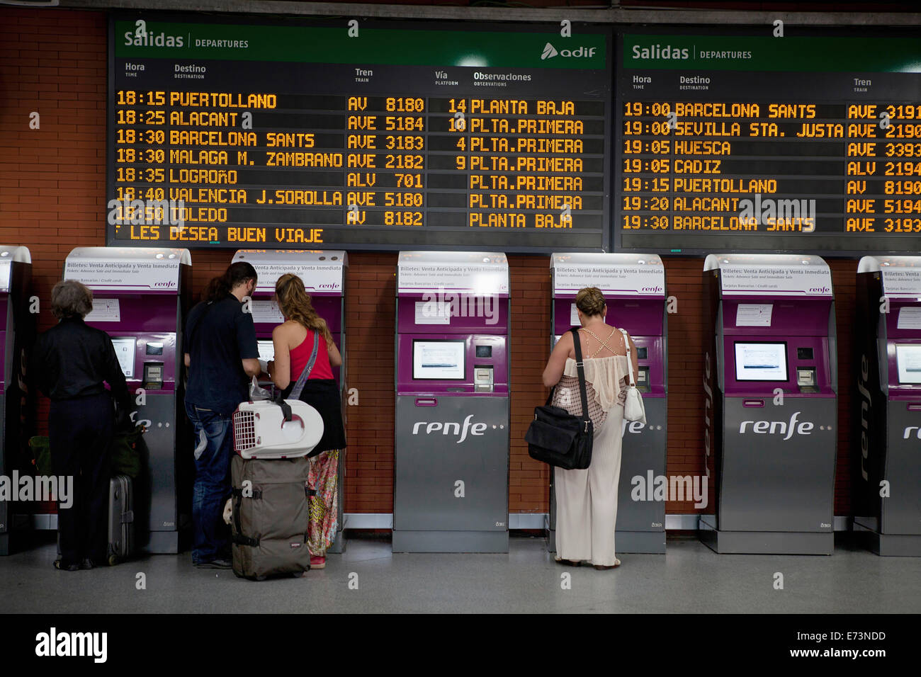 Spain, Madrid, Passengers using the self-service ticket machines in ...