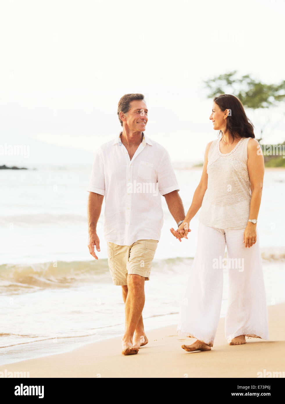 Mature Retired Couple Enjoying Sunset Walk on the Beach Stock Photo - Alamy