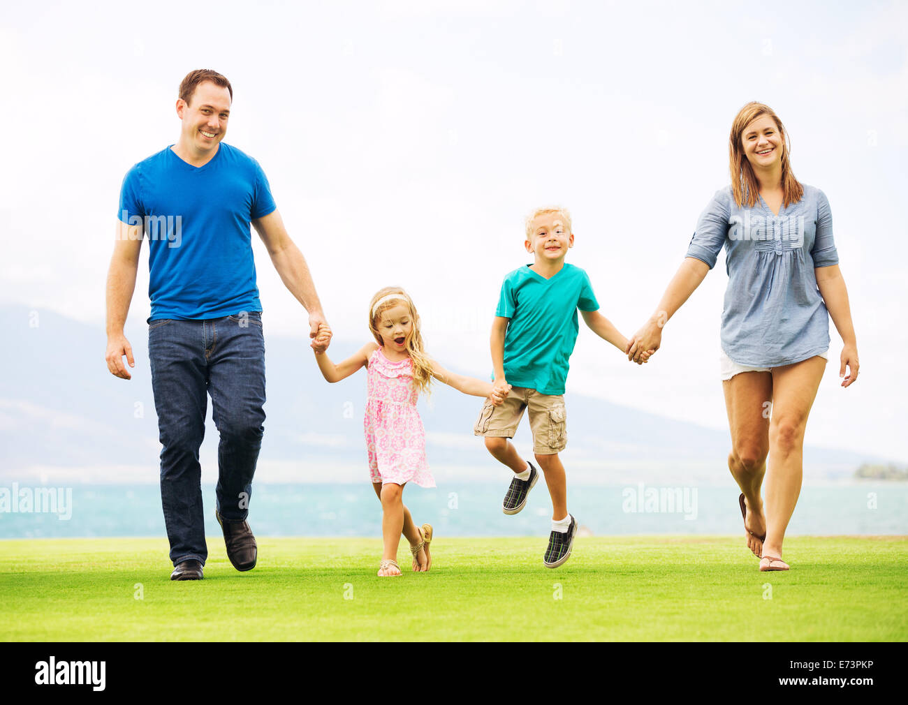 Happy Family Outside on Grass Stock Photo - Alamy
