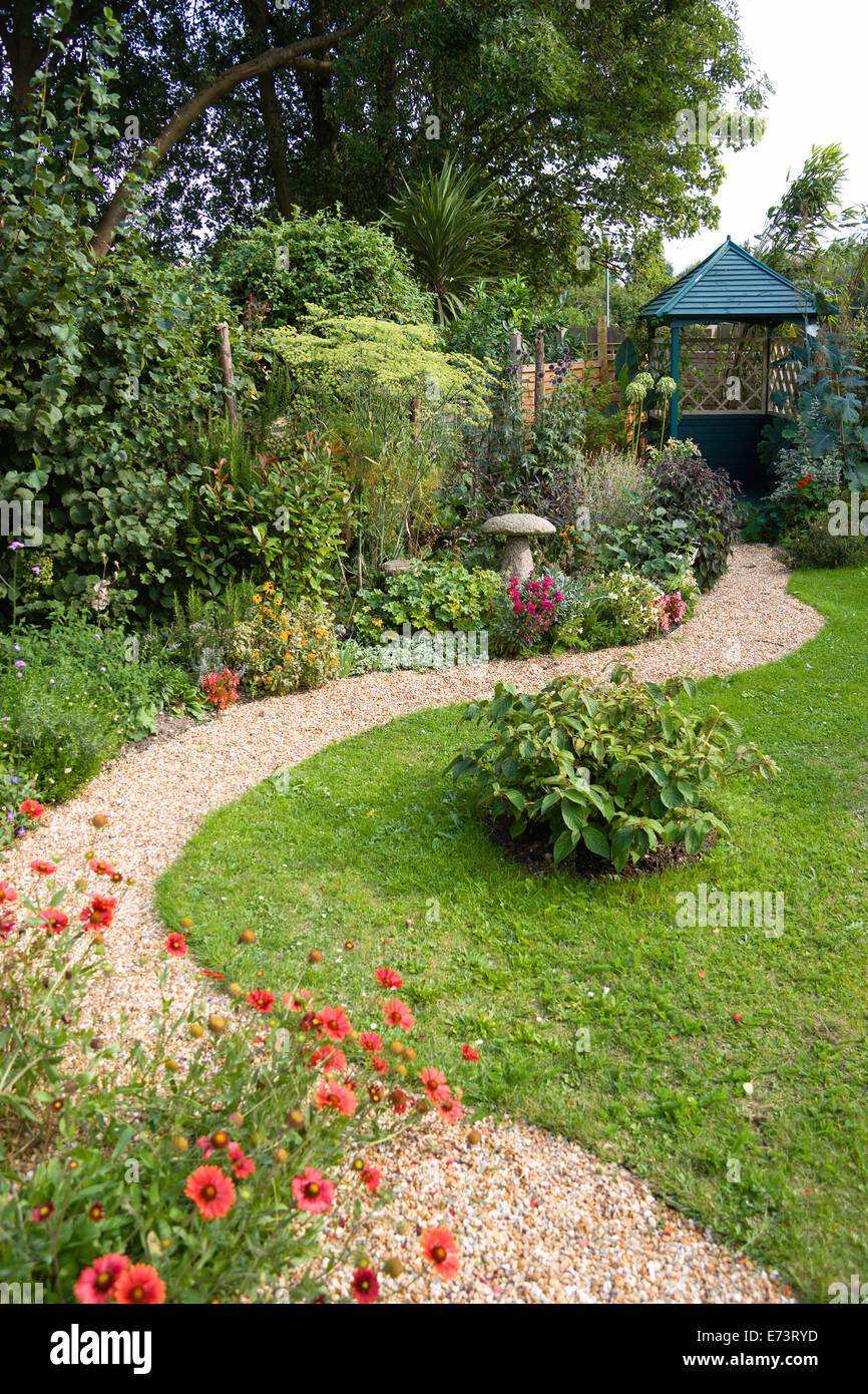 English cottage garden, winding shingle path leading to a gazebo ...