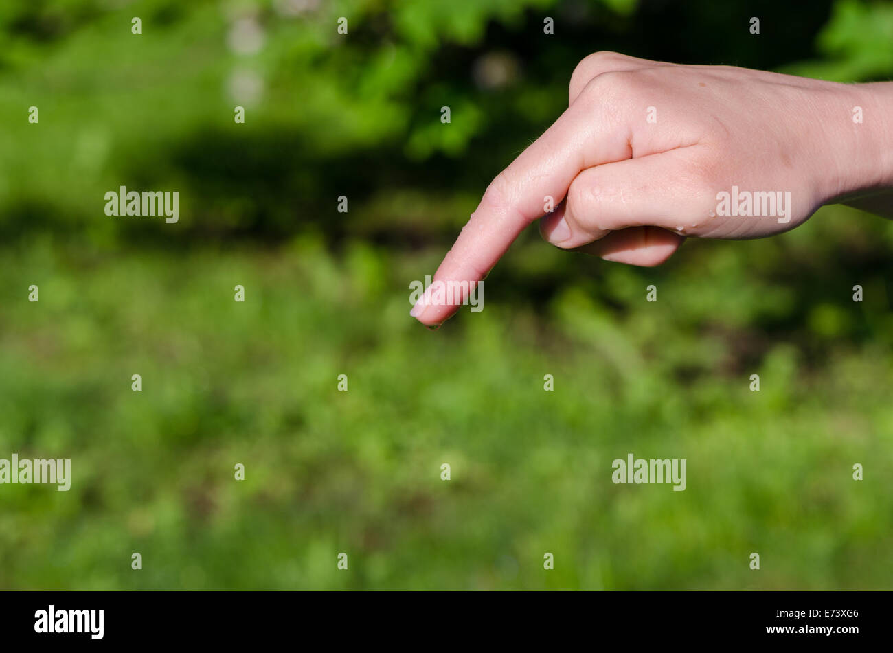 womans hand with water drop on the end of the finger on nature ...