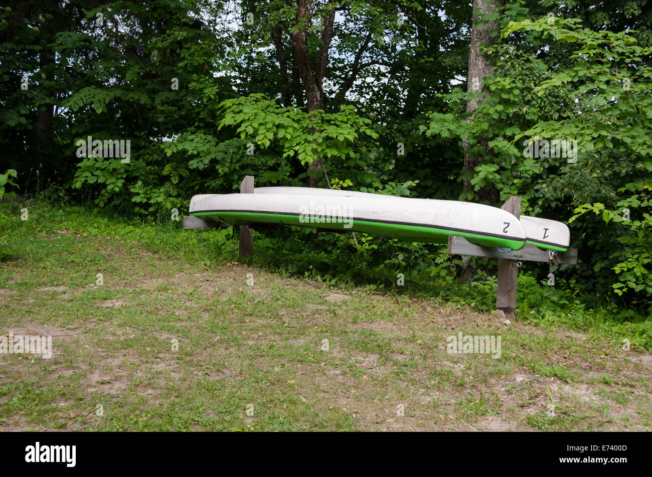 inverted two green canoes on wooden sticks dug into the ground Stock ...