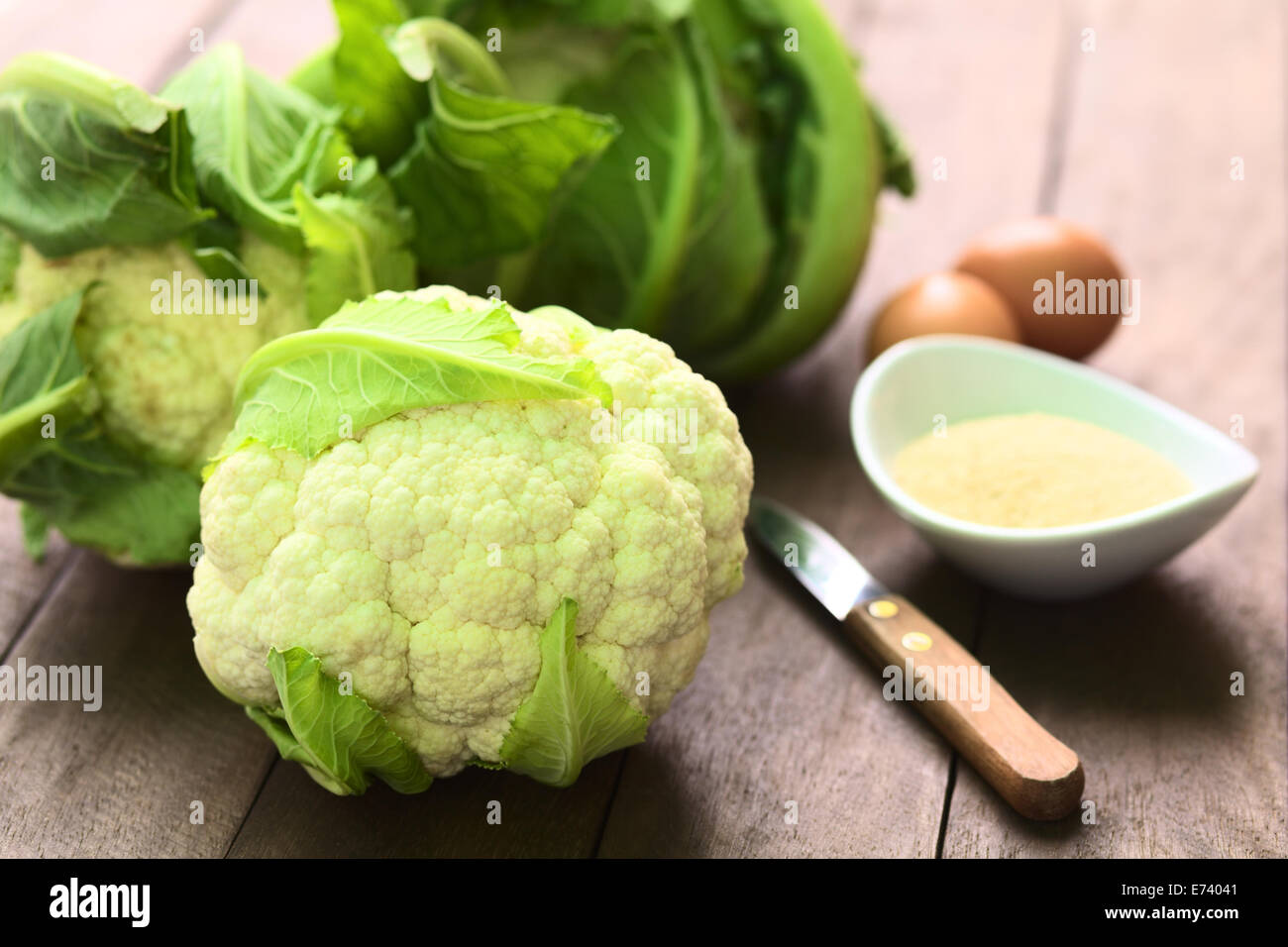 Raw cauliflower with breadcrumbs and eggs in the back for breading ...