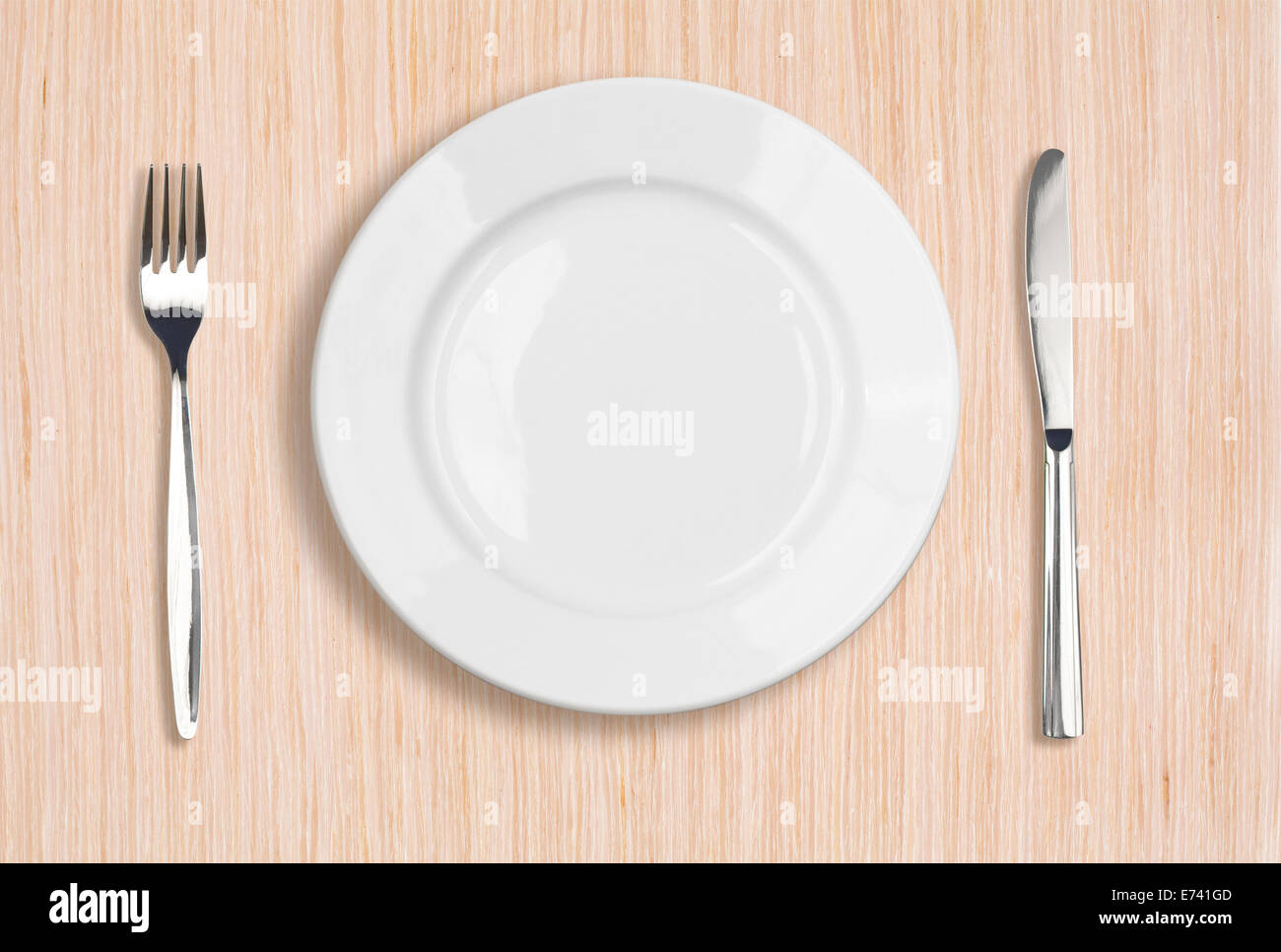 white plate, knife and fork top view on wooden table Stock Photo - Alamy