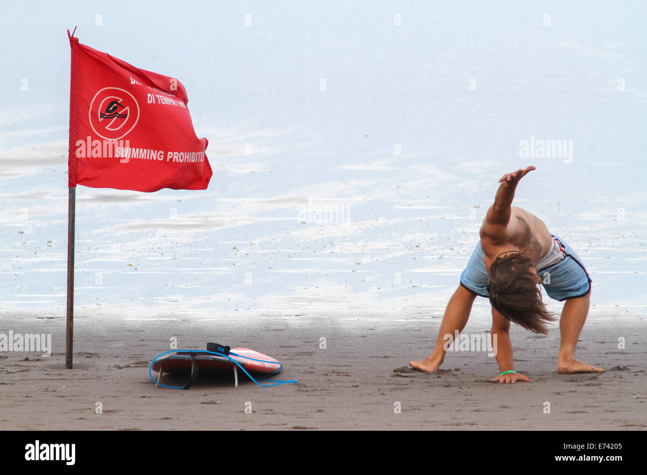 Red Flag and surfer on the beach Stock Photo - Alamy