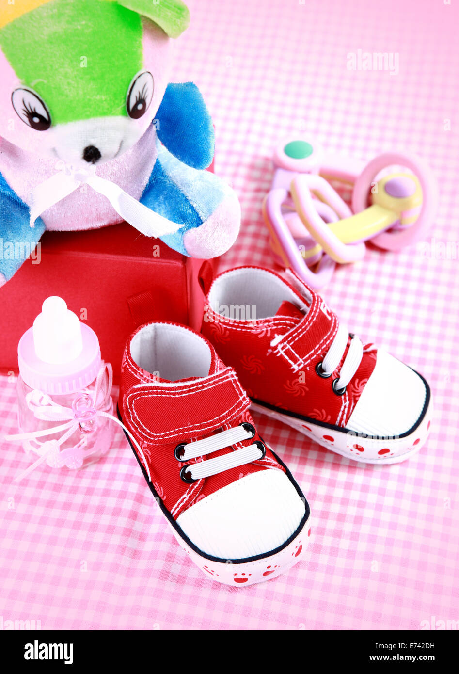 Red baby shoes on the pink plaid background Stock Photo - Alamy