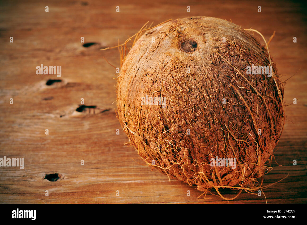 a coconut on a rustic wooden table Stock Photo - Alamy