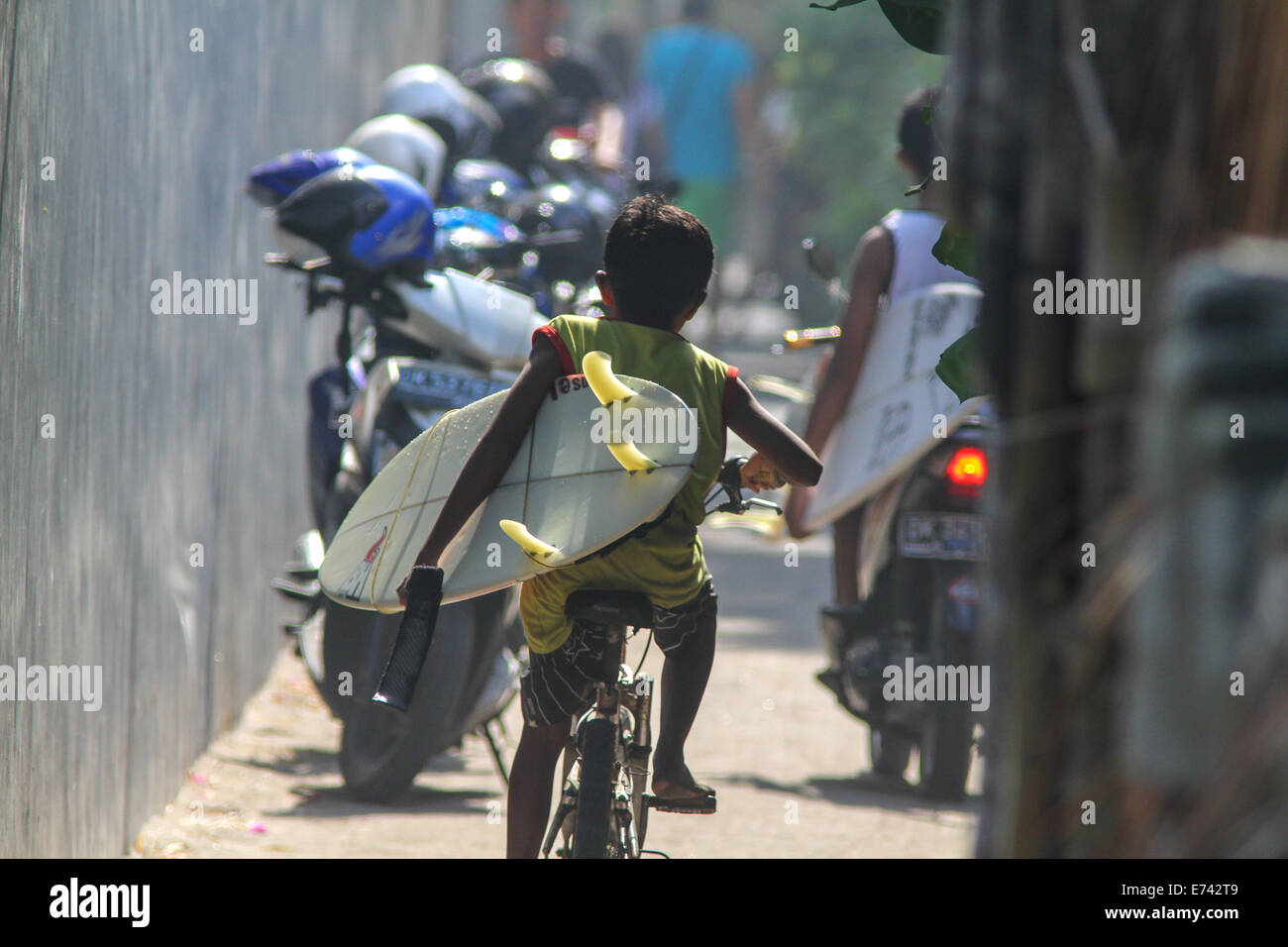 Young surfer on the bicycle Stock Photo - Alamy