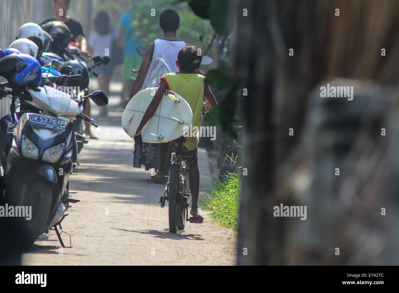 Young surfer on the bicycle Stock Photo - Alamy