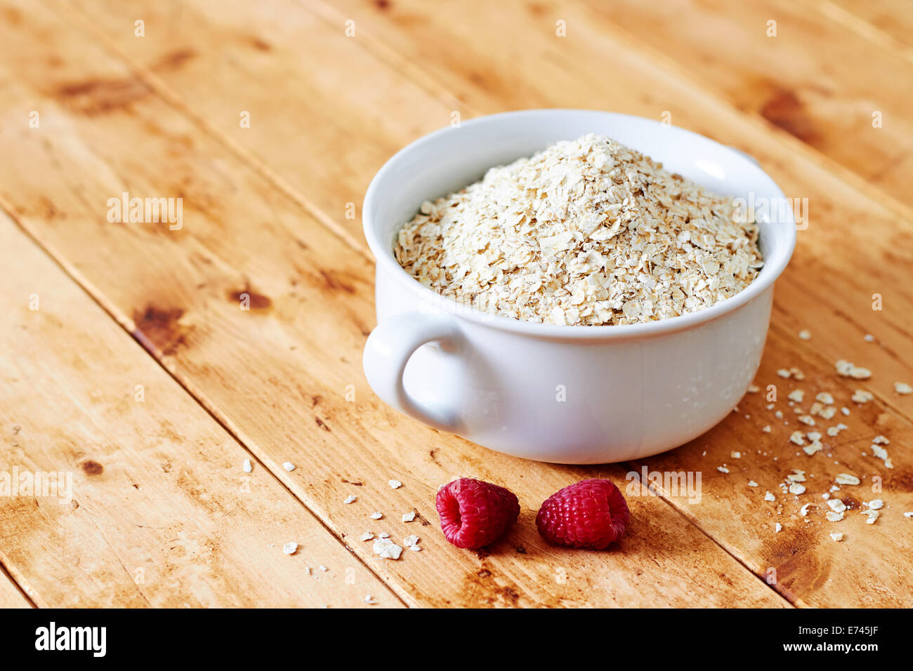 Raw oatmeal and raspberries Stock Photo - Alamy
