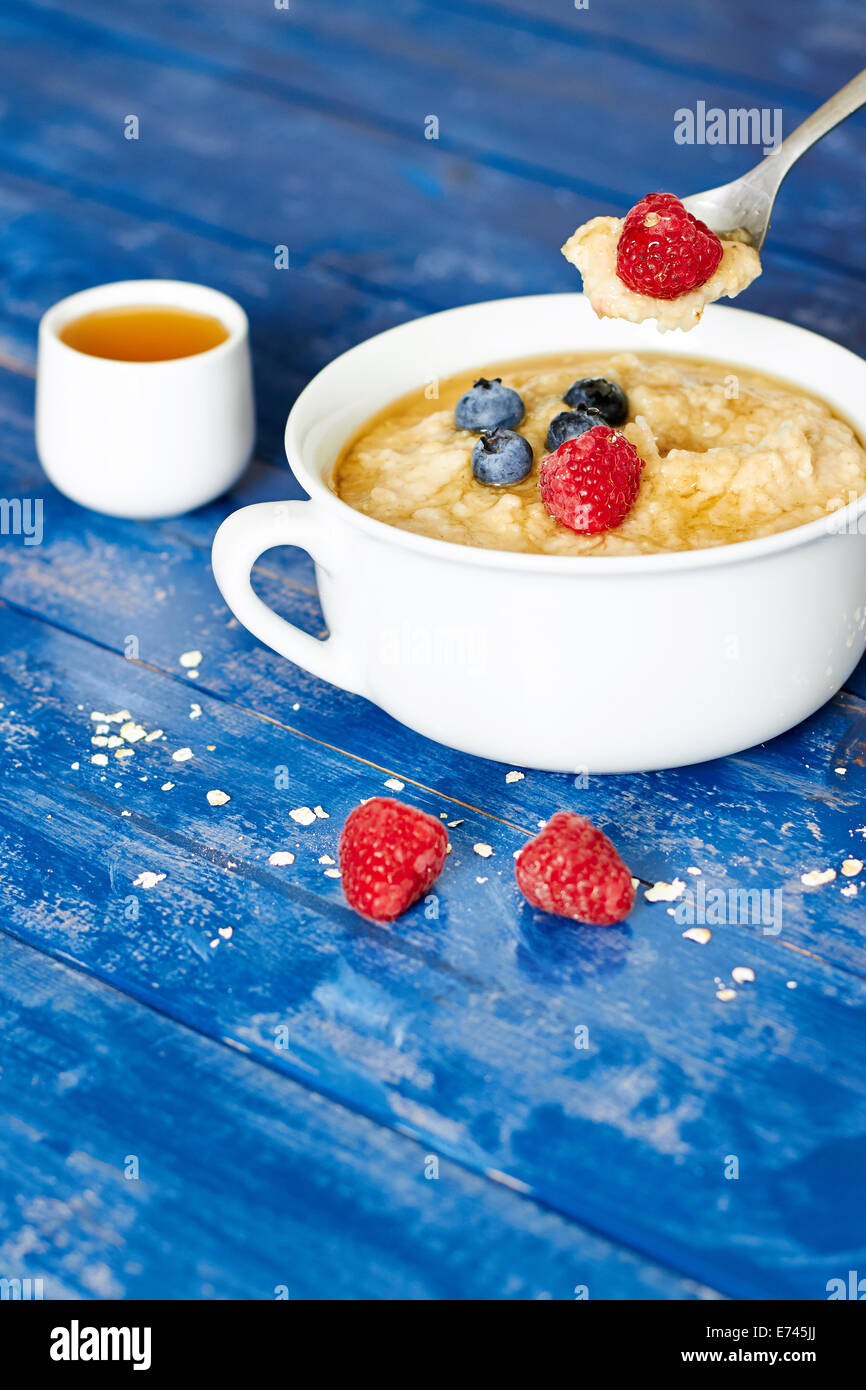 Porridge bowl with berries and honey on wooden table Stock Photo - Alamy
