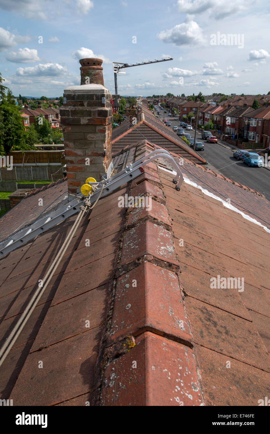 Roof top view of a chimney undergoing repairs, with a roof ladder and ...