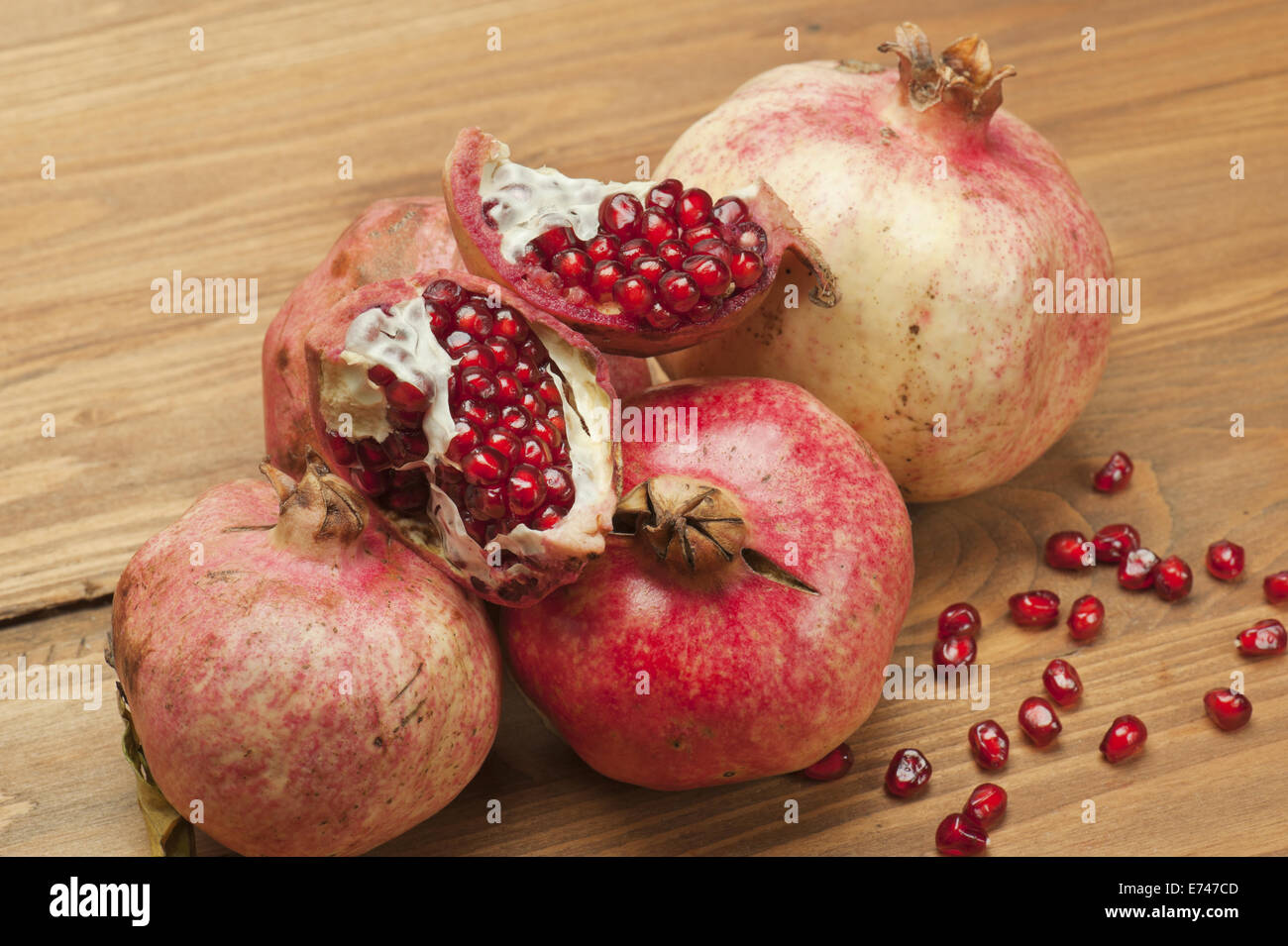 set of pomegranate with slice one on wood background Stock Photo - Alamy