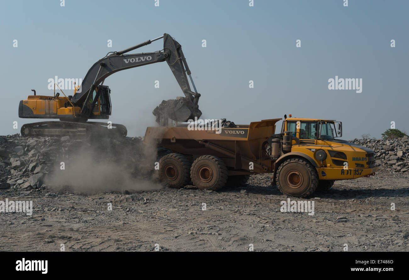 A Volvo mining dump truck is being loaded with rock by a Volvo ...