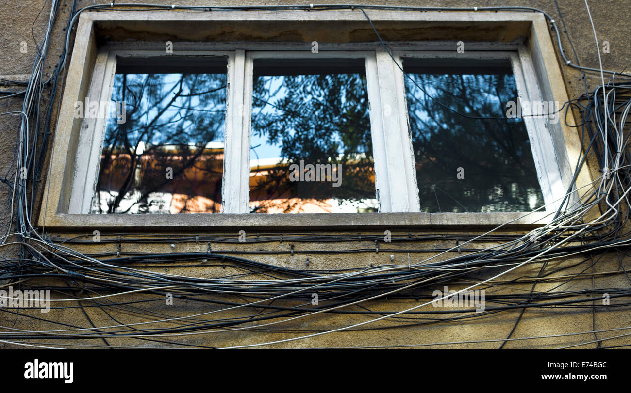 Messy wires around windows Stock Photo - Alamy