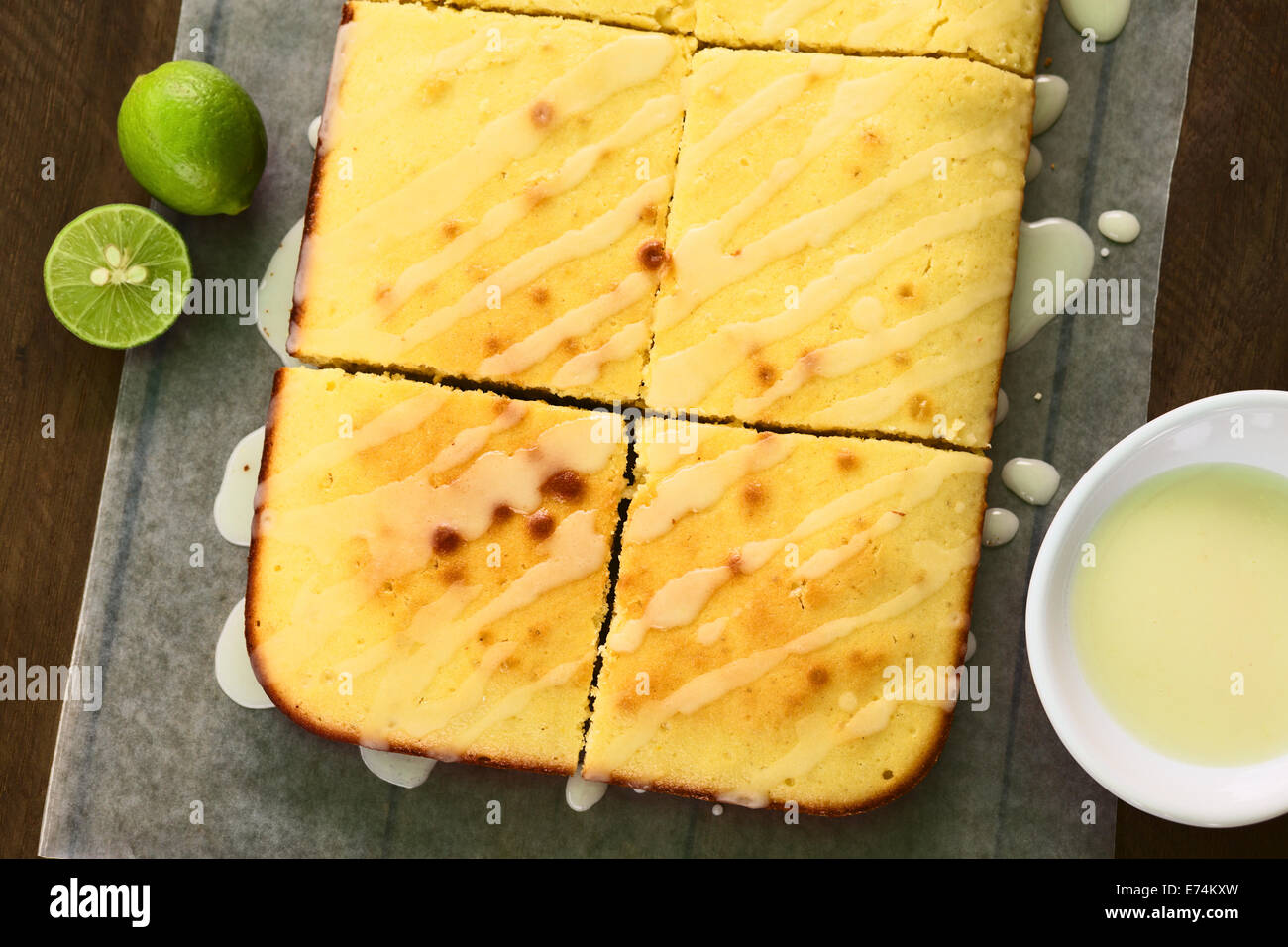 Fresh homemade key lime cake with lime icing on top on parchment paper ...