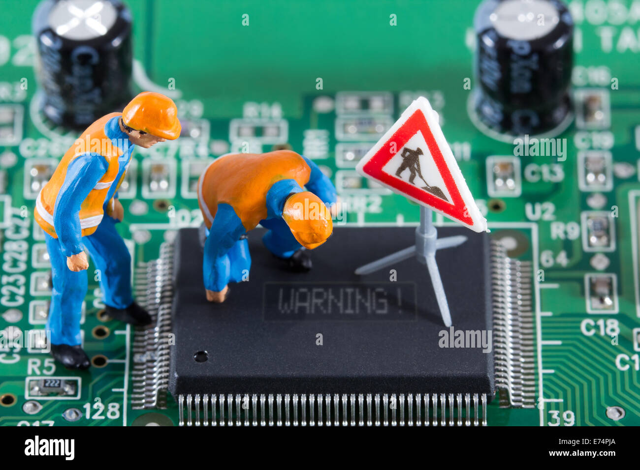 Miniature engineers fixing error on chip of circuit board. Computer repair concept. Close-up ...