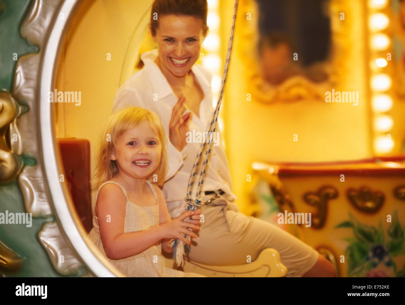 Portrait of happy mother and baby girl riding on carousel Stock Photo ...