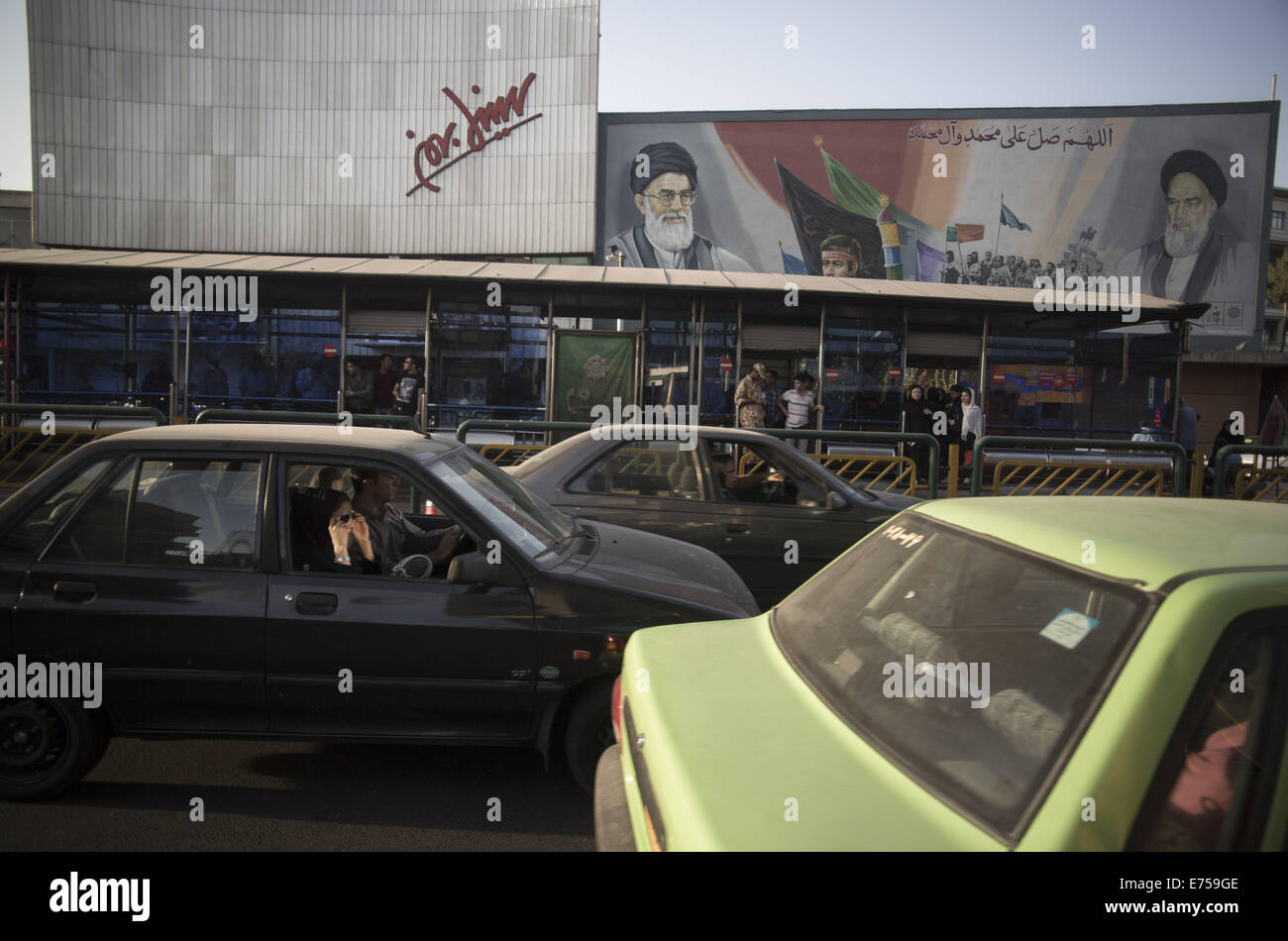 Tehran, Iran. 7th Sep, 2014. Cars drive past a mural with portraits of ...