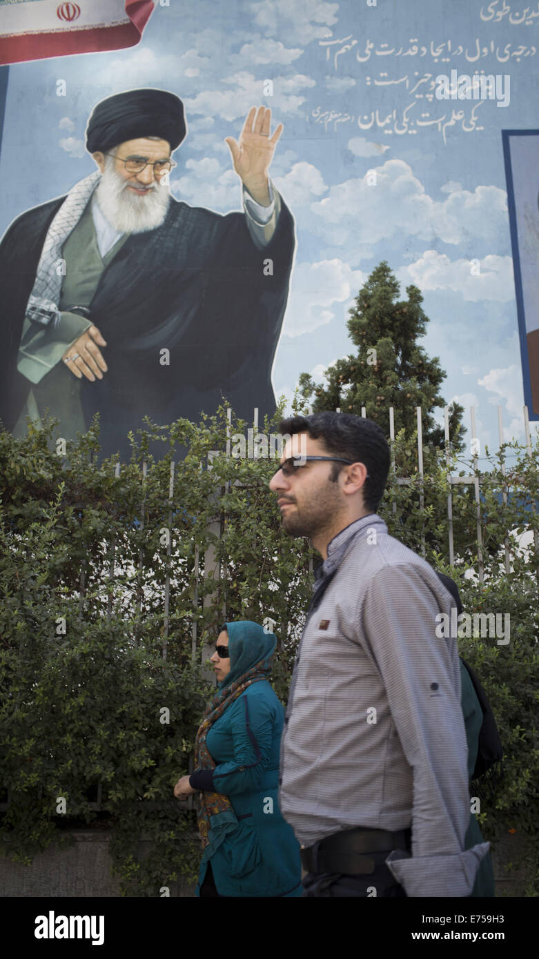 Tehran, Iran. 7th Sep, 2014. Iranians walk past a portrait of Iran's ...