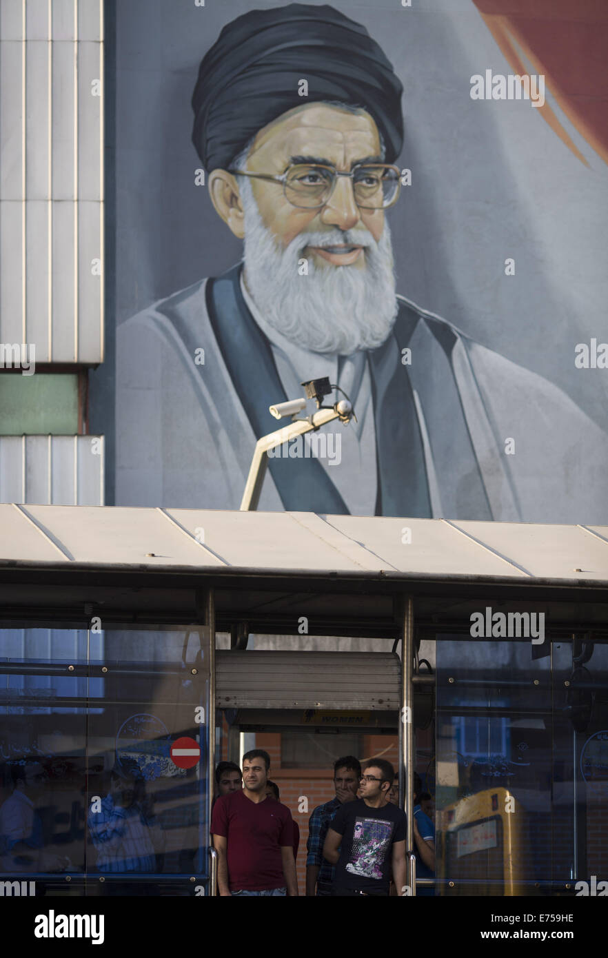 Tehran, Iran. 7th Sep, 2014. Iranian men stand at a bus stop under a ...